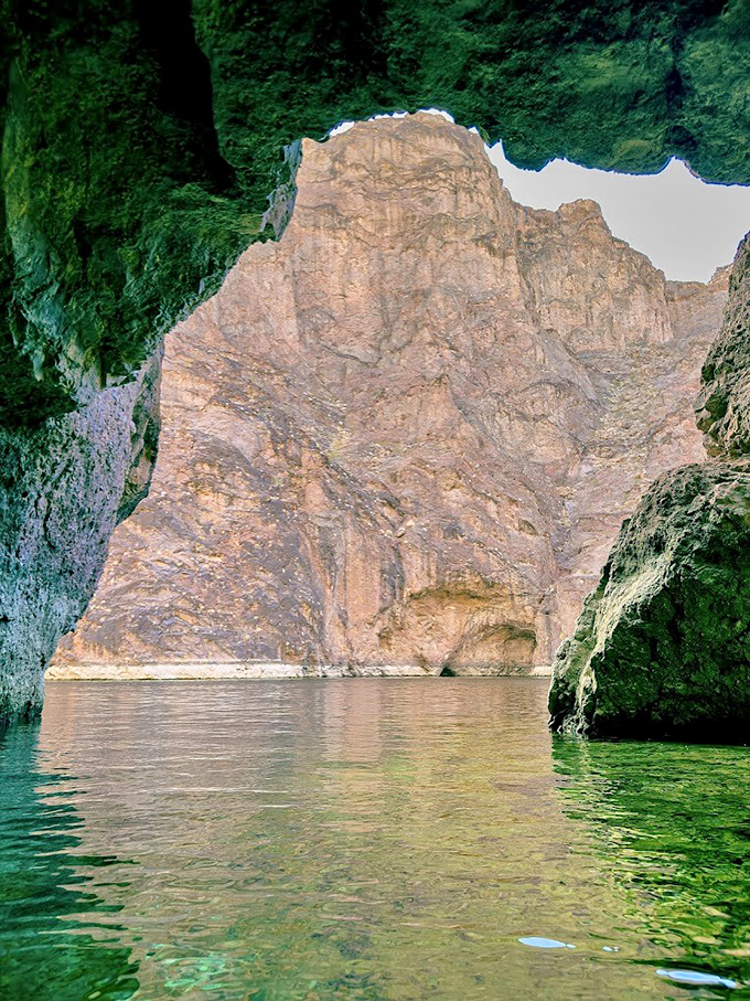 Looking out from inside Emerald Cave, the bright opening frames a perfect view of the Colorado River's stunning canyon landscape.