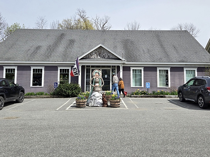 Discover unique local crafts as you walk toward this welcoming lavender building, greeted by a whimsical garden sculpture in Maine.