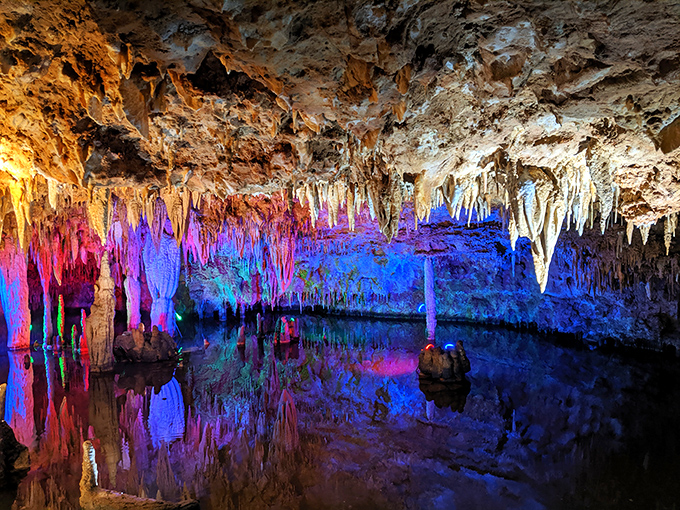 Nature's artwork glows in vibrant purples and blues, reflecting in the still waters of this spectacular underground river cave.