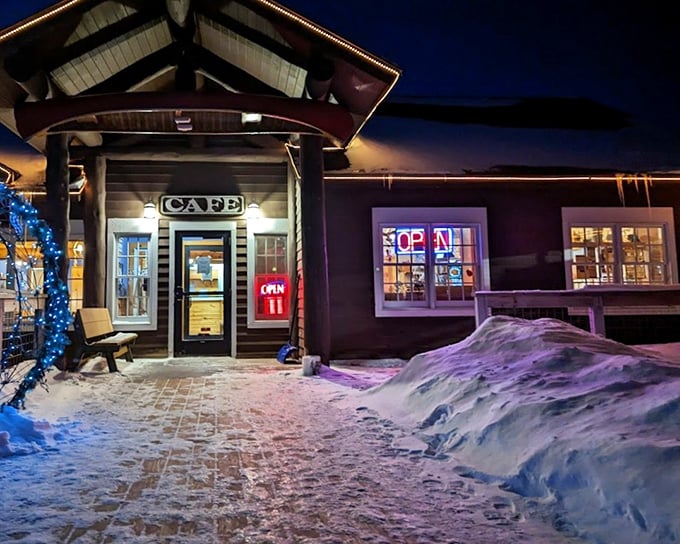 As night falls, the Rustic Inn Cafe glows with warm light against the snow, creating a cozy beacon for pie lovers even in Minnesota's winter wonderland.