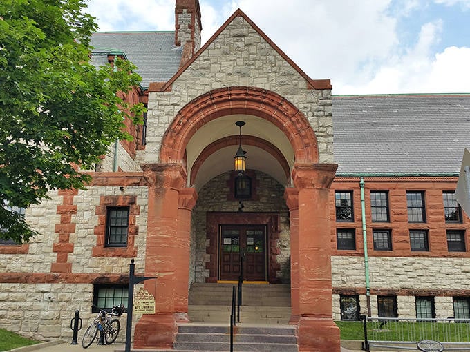 Brick patterns dance across the library's facade, creating a visual rhythm that draws the eye upward toward its crown-like roof.