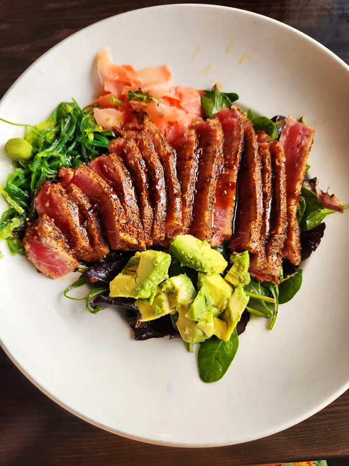 Seared ahi tuna, arranged like a work of art atop fresh greens with avocado and ginger – proof that healthy can be utterly indulgent.