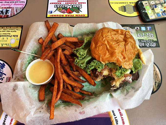 Burger: Sweet potato fries accompany this masterpiece burger &ndash; notice the perfectly toasted bun, fresh toppings, and special sauce dripping with anticipation.