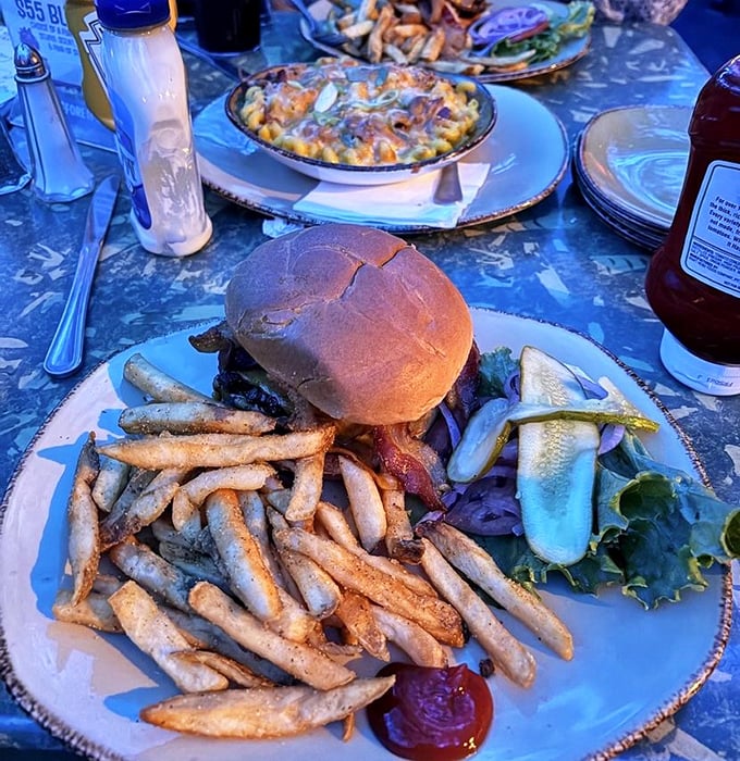 This juicy burger with a mountain of golden fries sits alongside creamy mac and cheese &ndash; comfort food that transcends geological eras.