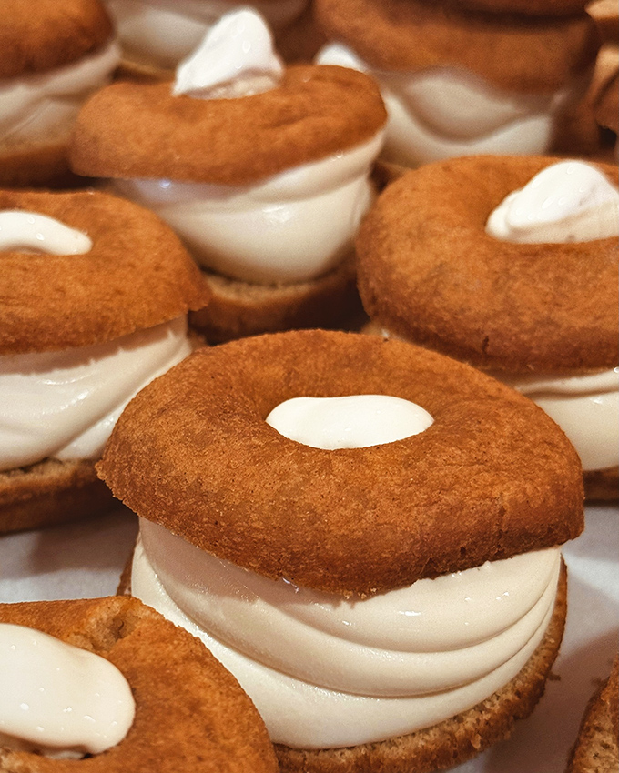 Donut sandwiches with creamy filling &ndash; because the only thing better than a cider donut is two cider donuts hugging a cloud of sweetness.