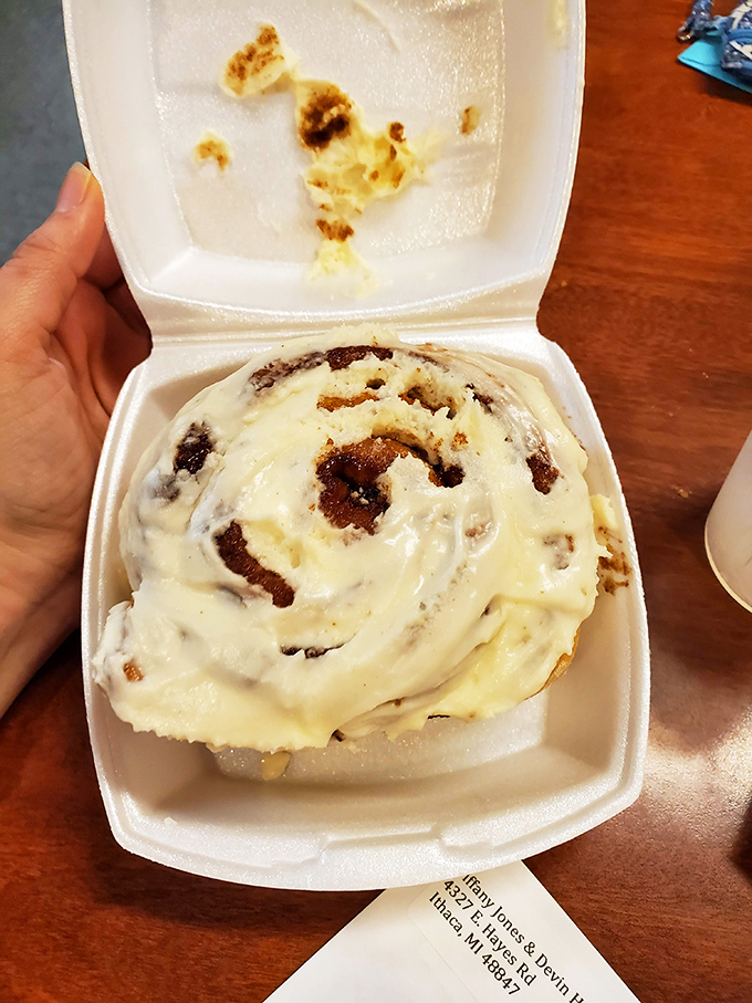 The cinnamon roll arrives like a sweet spiral galaxy of dough and spice, glazed with frosting that melts into every warm crevice.