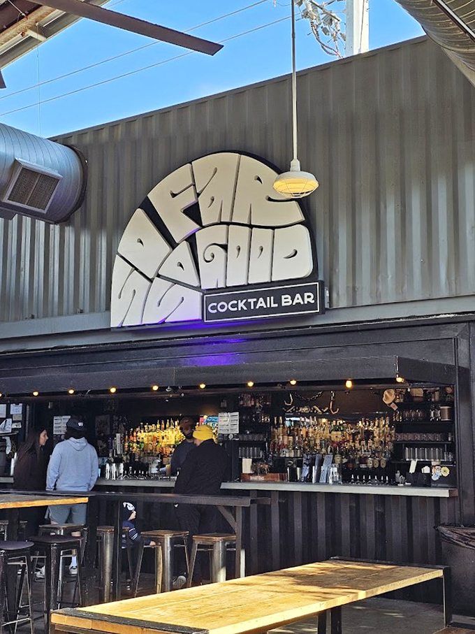 The cocktail bar's retro-cool signage promises good times ahead, while bartenders craft drinks with equal parts precision and flair.