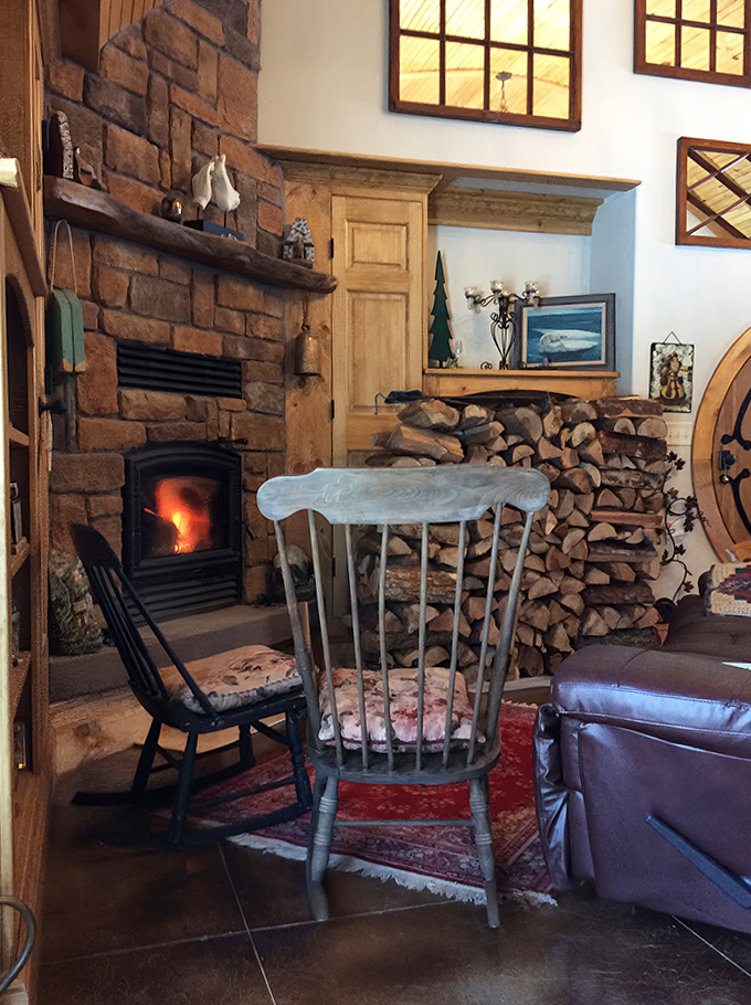 The cozy living area centered around a stone fireplace invites guests to settle in with a good book or second breakfast.