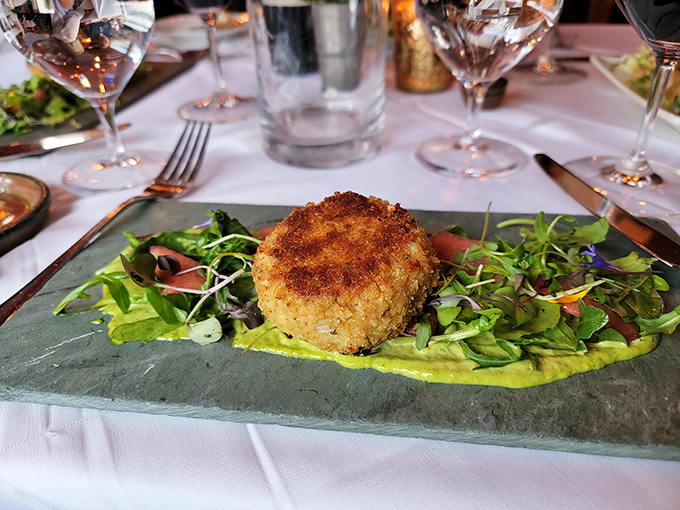 This isn't just any crab cake &ndash; it's a golden-crusted island of sweet lump crab meat floating on a sea of vibrant sauce.