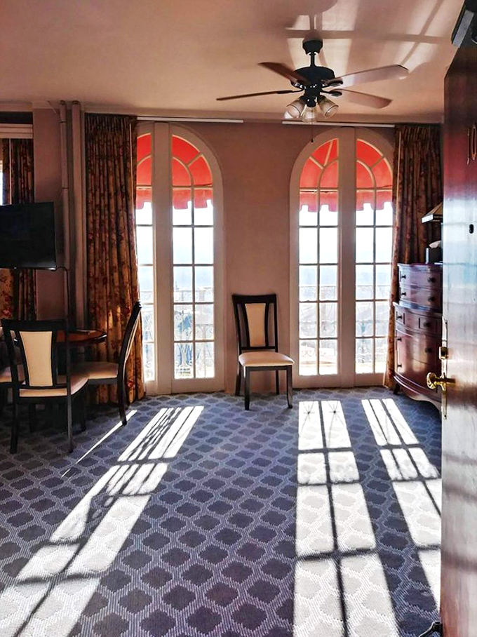 Sunlight streams through arched windows in this deluxe guest room, creating dramatic shadows that sometimes move in ways shadows shouldn't.
