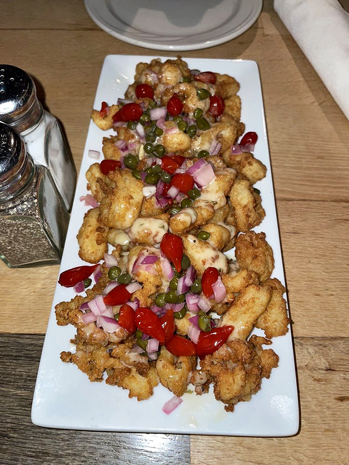 Crispy calamari topped with colorful peppers and onions &ndash; a starter that disappears faster than the tide changes.