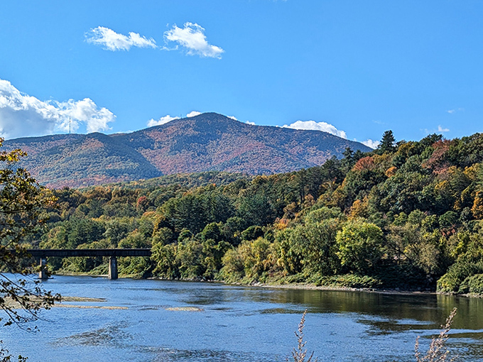 Nature's majesty surrounds the bridge, with rolling hills and the winding Connecticut River creating a quintessential New England landscape.