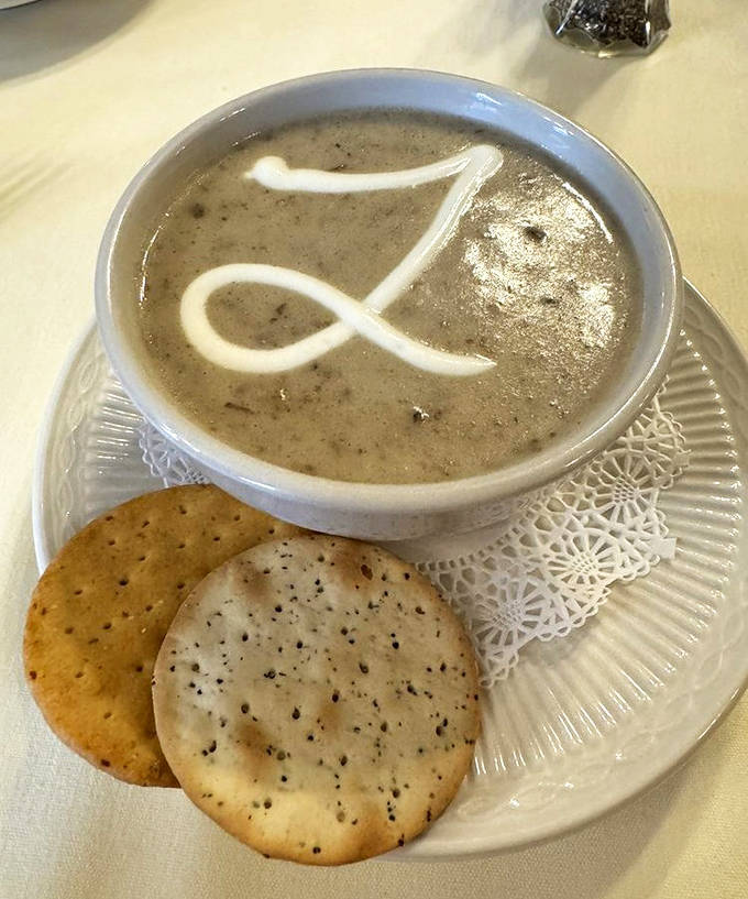 The signature cream of mushroom soup arrives with an artistic swirl of cream &ndash; velvety, rich, and complex enough to make you reconsider everything you thought you knew about soup.