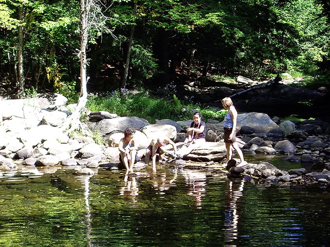 Riverside relaxation: smooth stones create nature's perfect lounge chairs, warmed by sunshine and cooled by occasional splashes from nearby swimmers.