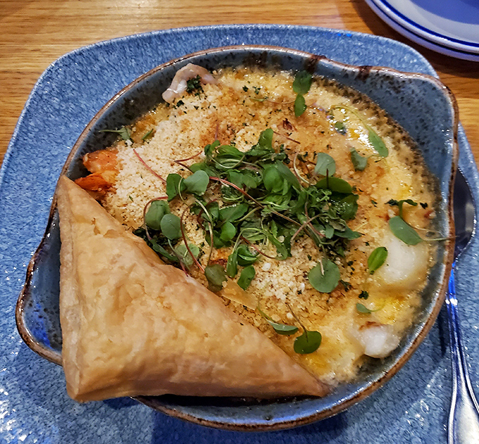 Bubbling seafood casserole that whispers, "Cancel your plans for the afternoon." That pastry triangle isn't decoration &ndash; it's your dipping tool.