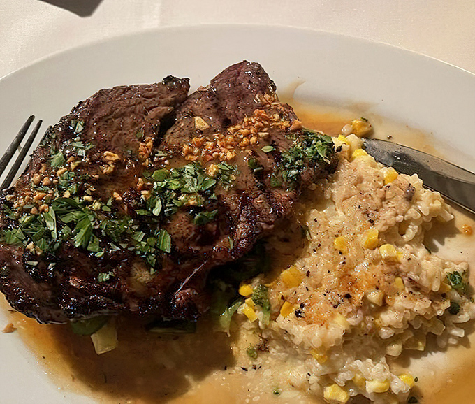 A perfectly seared ribeye rests beside creamy risotto &ndash; the kind of plate that makes conversation stop and eyes close in appreciation.