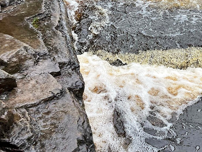 The hypnotic swirl of amber waters against dark rock creates nature's own lava lamp effect, mesmerizing visitors into peaceful contemplation.