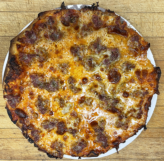 Sausage Pizza: The fennel-kissed sausage crumbles spread across that impossibly thin, crispy crust create the kind of simple perfection that's kept locals coming back for generations.