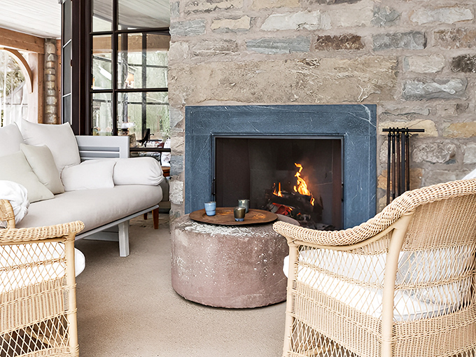 Wicker chairs and a crackling fire create the perfect spot for evening conversations or morning coffee contemplation.