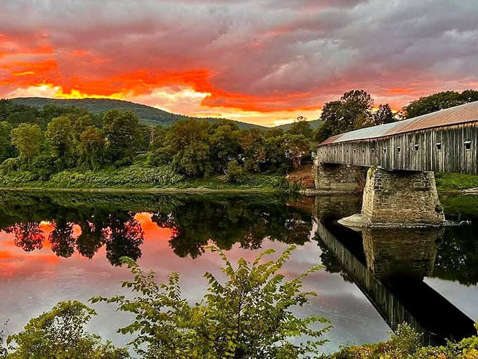 Sunset paints the Connecticut River in fiery hues, with the bridge standing as a silhouetted sentinel against nature's nightly masterpiece.