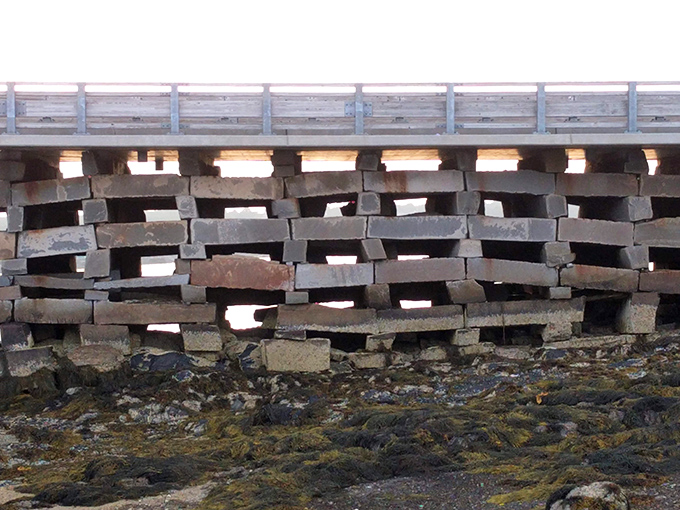 The bridge at low tide exposes more of its remarkable stone foundation, built to withstand Maine's challenging coastal conditions.