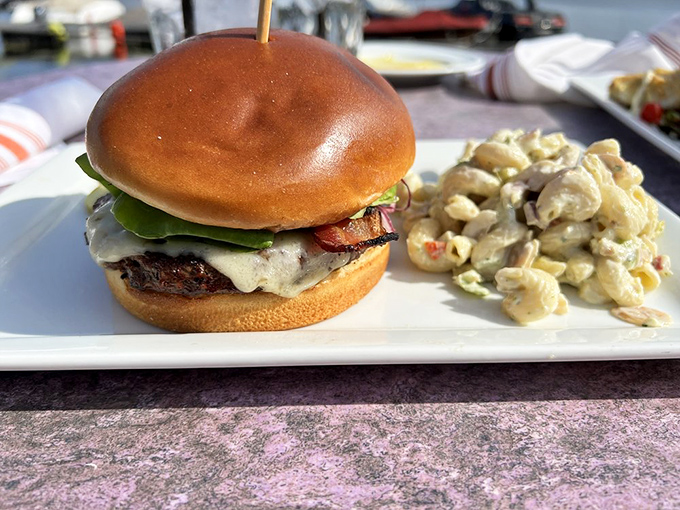 A perfectly proportioned burger on a golden bun, accompanied by pasta salad that didn't get the memo about side dishes being afterthoughts.