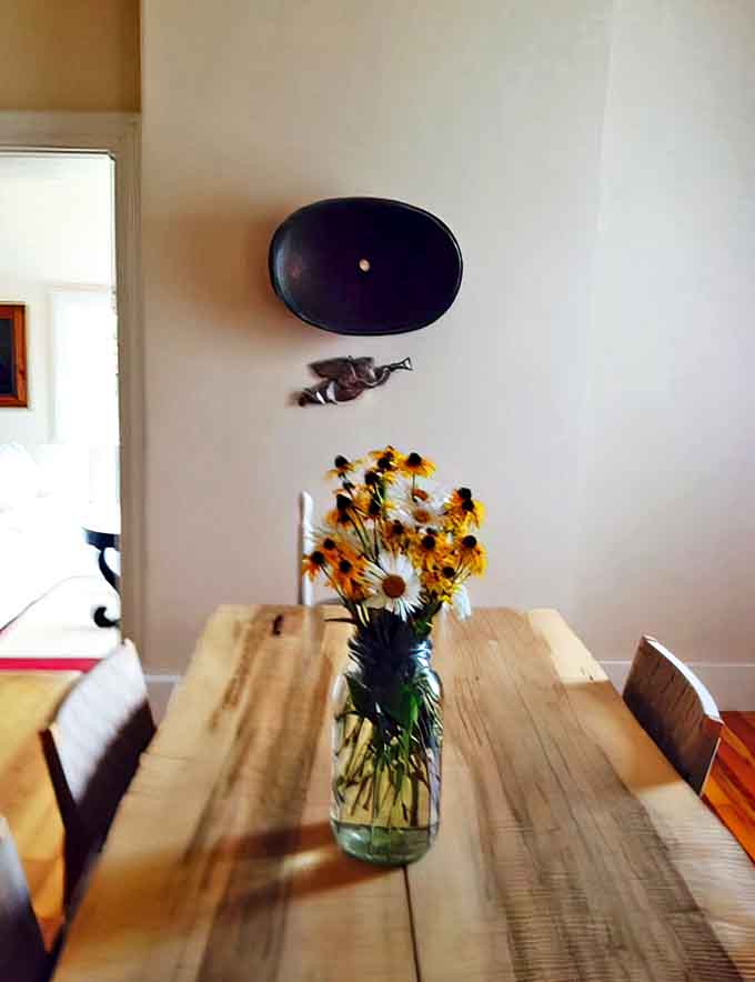 Fresh wildflowers brighten the rustic dining area, where meals become memorable events against the backdrop of maritime history and lakeside views.