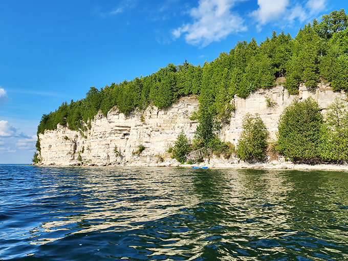 Dramatic limestone cliffs rise from Lake Michigan's waters, their geological makeup providing the essential materials that made Fayette possible.