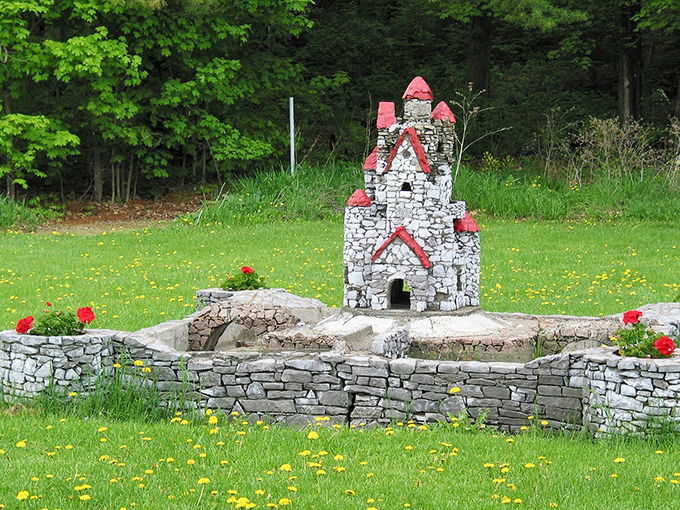 Bright red turrets reach skyward, adding playful charm to this miniature castle surrounded by spring dandelions.
