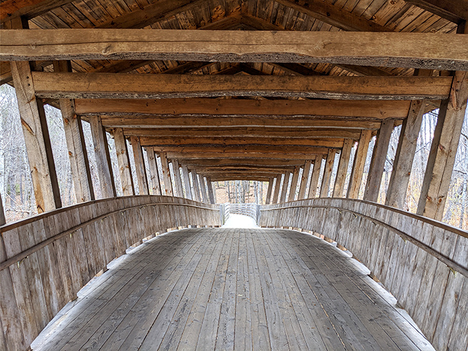 The covered bridge interior creates a tunnel-like perspective, drawing your eye forward to the light beyond.
