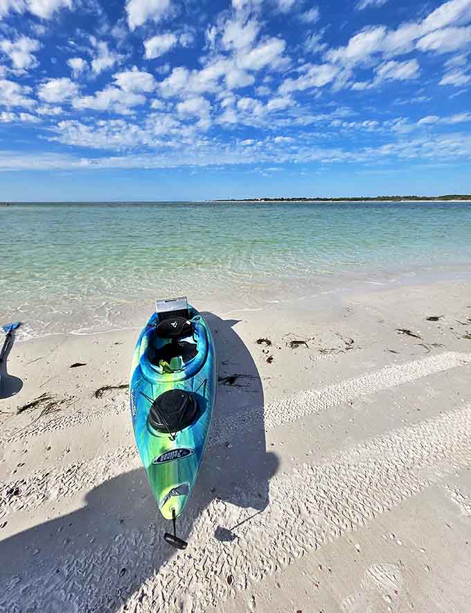 Adventure awaits: A colorful kayak rests on Caladesi's sugar-white sand, ready to transport explorers through mangrove tunnels and along untouched shorelines.