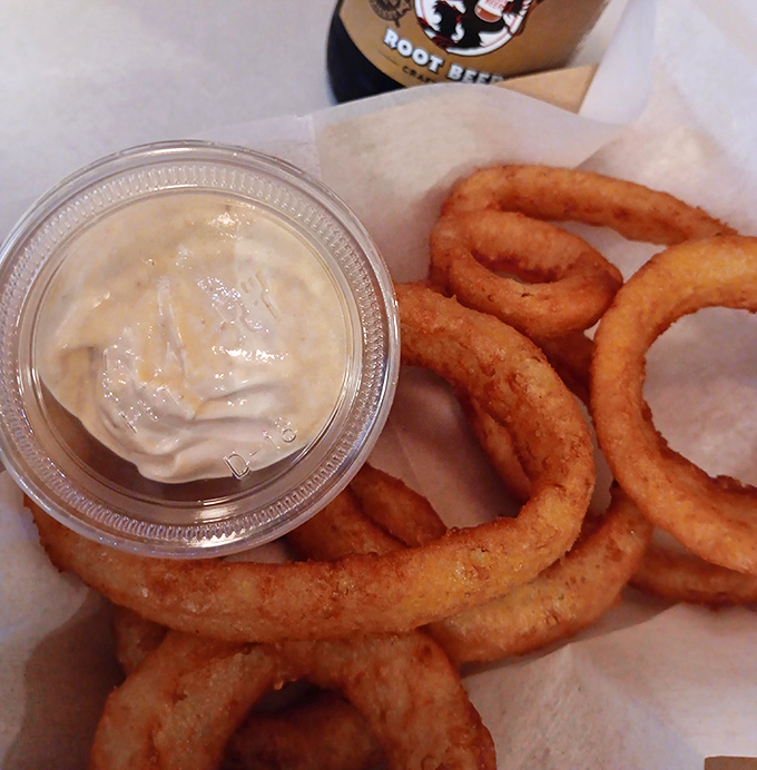 Golden onion rings with a side of sauce prove that sometimes the simple pleasures are the best pleasures.