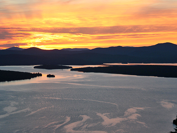 Sunset transforms the lake into liquid gold, a reminder that timing is everything on this magical route.