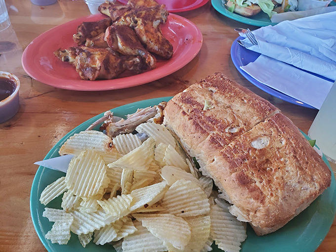 A sandwich worthy of epic poetry, served with crispy chips on a turquoise plate – comfort food elevated to art form.