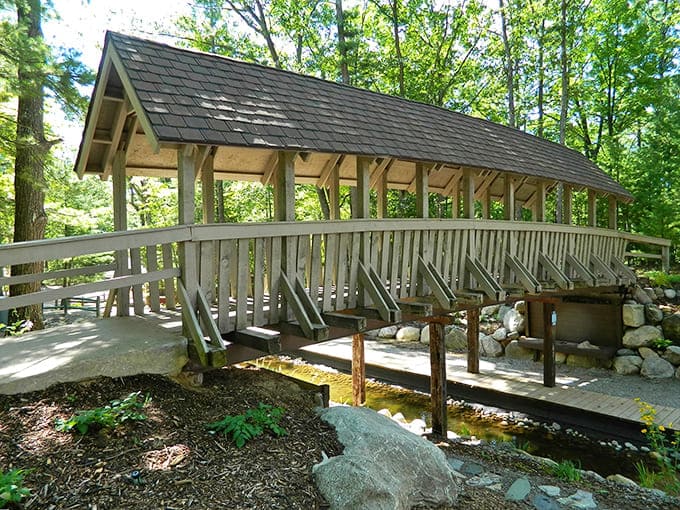 Summer's vibrant greens frame this wooden covered bridge, creating a magical portal that seems to transport visitors to another world.