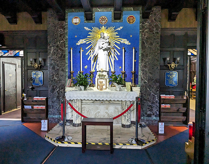 The simple elegance of this worship area invites quiet contemplation, with its blue backdrop creating a heavenly atmosphere for the central figure.