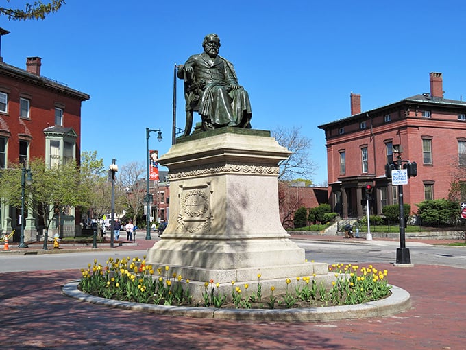 Portland's Soldiers and Sailors Monument stands proudly in Monument Square, surrounded by spring flowers and historic buildings.