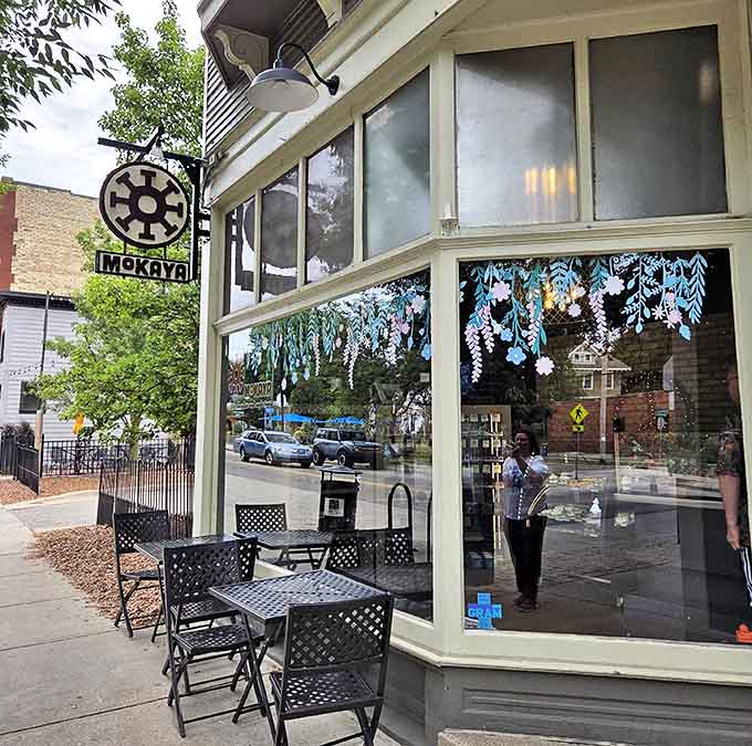 Mokaya's storefront blends historic charm with artistic flair, featuring hand-painted wisteria and outdoor seating for chocolate contemplation. Urban chocolate oasis in Grand Rapids!