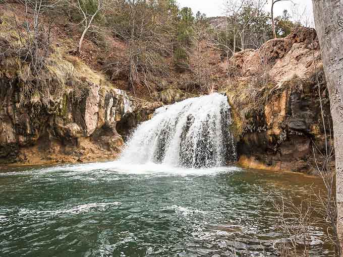 Mountain waterfall cascades over rocks, offering the ultimate natural air conditioning for summer visitors.