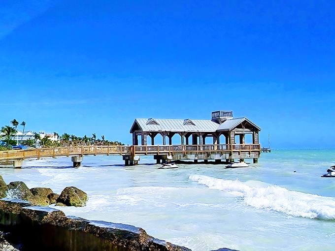 The wooden pier at Key West extends over calm waters, its covered pavilion offering shade for fishing, contemplation, or simply soaking in paradise.