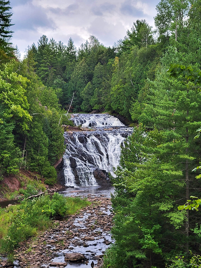 Multiple tiers of rushing water create a dramatic scene at Potato River Falls, especially vibrant when framed by autumn foliage.