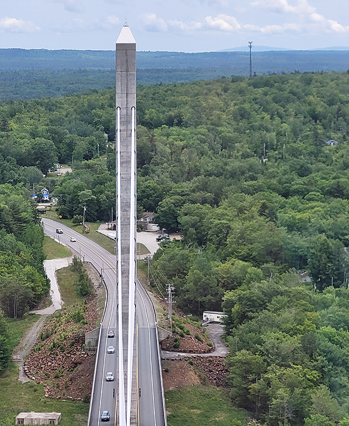 The Penobscot Narrows Bridge soars dramatically above the Maine landscape, its modern design creating a striking contrast to the historic fort below.
