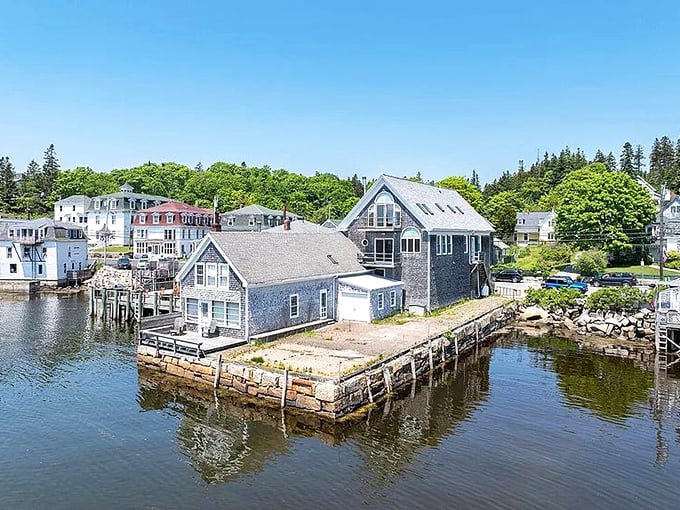 Houses perch along Stonington's rocky shore, with boats in the harbor suggesting the town's deep connection to the sea.