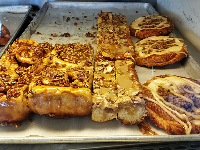 Caramel rivers flow over buttery pastries topped with nuts, creating the kind of breakfast that makes mornings worth waking up for despite reality.