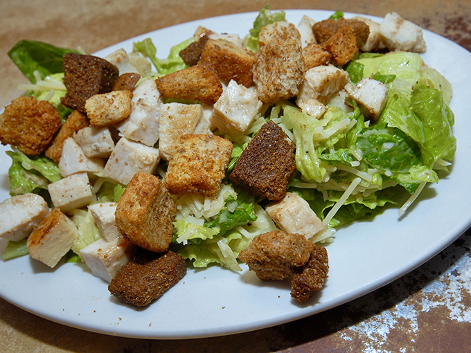 The Caesar salad provides the perfect fresh counterpoint to all that delicious pizza – crisp, garlicky, and generous.