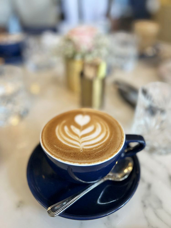 Coffee served with such artistic flair, you almost feel guilty disturbing the pattern. Almost. That blue cup elevates caffeine to a ceremonial experience.