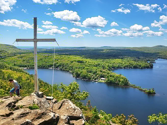 Spiritual heights: The memorial cross at Maiden Cliff stands sentinel over Megunticook Lake's shimmering waters.