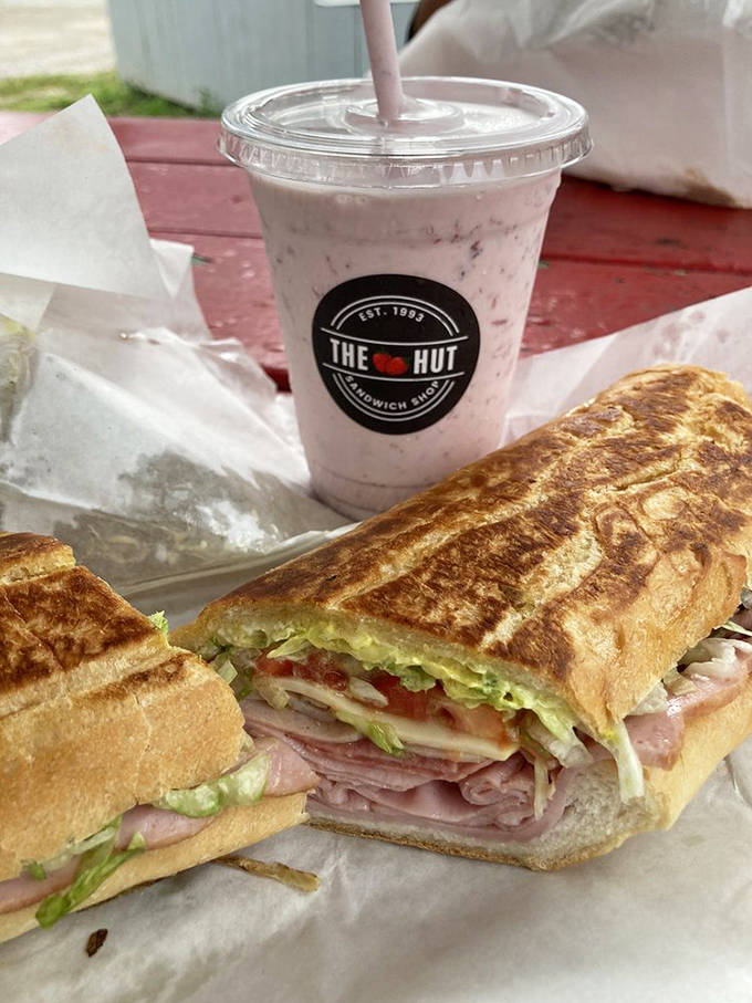 The perfect pairing: a pressed Cuban sandwich alongside a strawberry milkshake made with real berries. Sweet meets savory in this classic Florida lunch combo.