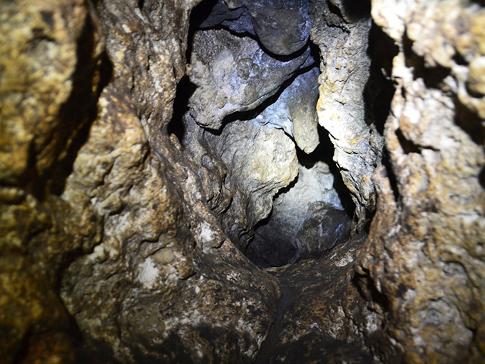 Peering into the cave's mysterious depths reveals nature's sculpture gallery, where water and time have carved limestone into fantastic formations.