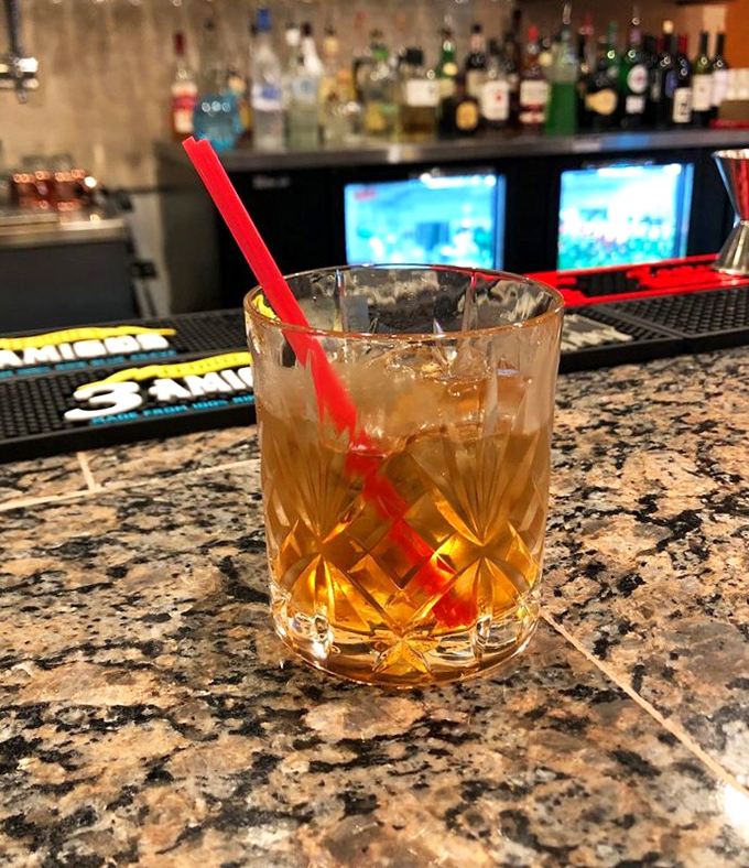 Amber liquid catches the light in a cut-crystal glass &ndash; a perfectly balanced cocktail that complements the bold flavors without overwhelming your palate.